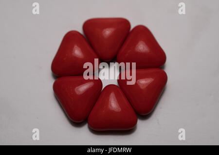 Closeup of red triangle pills looking like heart shaped candy isolated ...