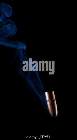 Copper plated bullet with smoke behind coming at the camera Stock Photo ...