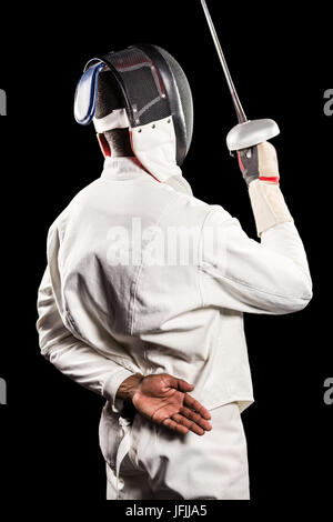 Man holding sword behind his back Stock Photo - Alamy