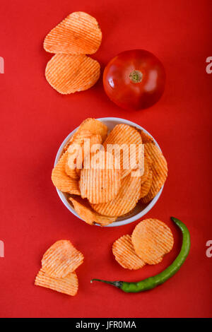 Potato chips arranged with tomato and green chili Stock Photo - Alamy