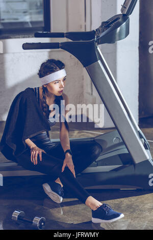 side view of tired sportive woman lying on treadmill in gym Stock Photo ...
