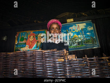 Gurage girl inside her traditional house in front of the fireplace ...