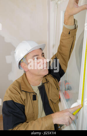 builder measuring the window seal of a construction Stock Photo - Alamy