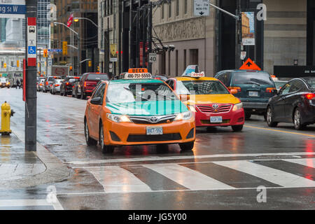 Taxis on a street in downtown Calgary, Canada. The yellow cabs are a ...