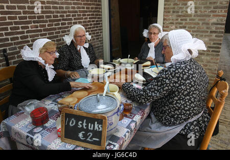 Senior women wearing traditional Dutch caps or bonnets made of white ...