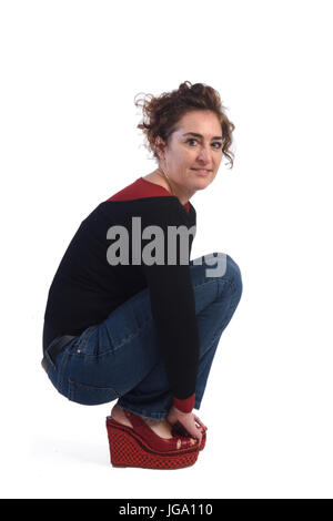 Pretty Female Model crouching looking at the camera Stock Photo - Alamy