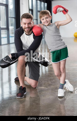 Child boy sportsman at boxing training with coach. Kid and trainer in ...