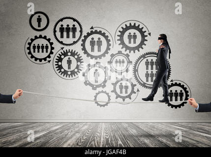 Businessman with blindfolder on eyes walking on rope over cityscape ...