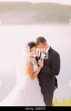Sensitive portrait of the groom hugging the pretty bride back Stock ...