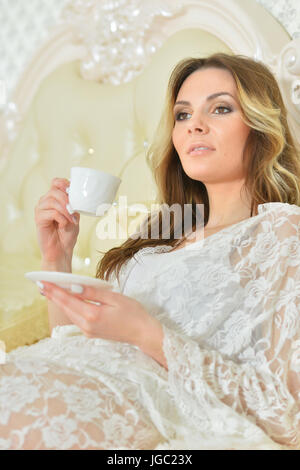 Fresh roasted coffee beans young worker woman packing machine in vacuum ...