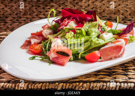 Mix of salads with prosciutto and mini mozzarella Stock Photo - Alamy