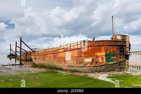 Derelict, rusting ships beached in the mud flats of the Humber estuary ...