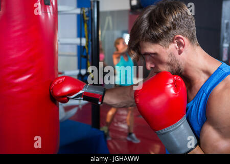 Side view of a young male boxer in a fighting stance on black ...
