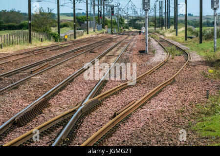 Parallel railway tracks with curved cutting, signals and overhead ...