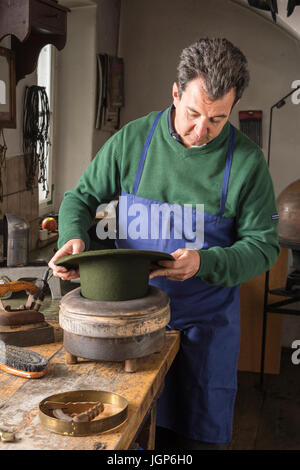 Hatter pushing dry wool felt hat into edge mold, hatmaker workshop, Bad ...