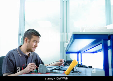 Mid adult electrical engineer working in manufacturing plant Stock ...