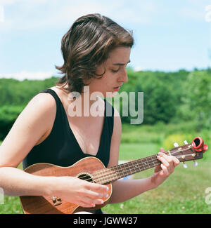 Young woman musician playing ukulele at music studio Stock Photo - Alamy