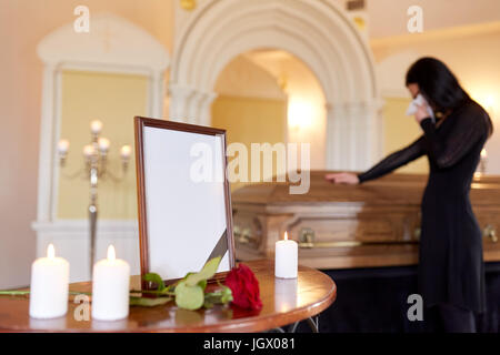 crying woman with red rose and coffin at funeral Stock Photo - Alamy