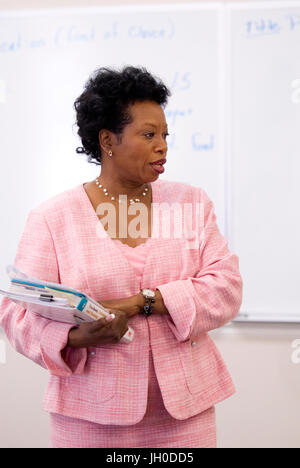 An African American professor teaches a class while standing at a ...