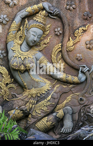 A statue of Mae Thorani, a Buddhist earth goddess, who wrings water out ...
