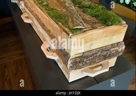 A coffin made of natural wood covered with moss on top in a morgue ...
