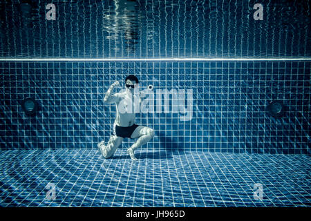 Man posing as Superman underwater swimming pool Stock Photo - Alamy
