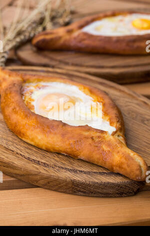 Fresh homemade khachapuri Ajarian on rustic wooden background. Dough ...