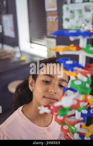 High angle view of a female student sitting against bookshelf and ...
