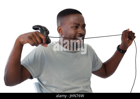 Frustrated man biting a wire of joystick against white background Stock ...