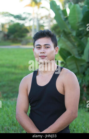 A handsome young Filipino male model in yellow shorts and striped shirt ...