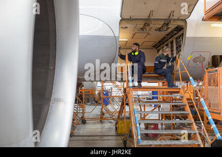 Aircraft maintenance engineers working over internal structure of an ...