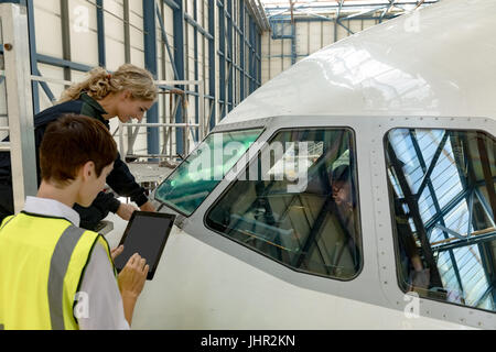 Aircraft maintenance engineers working over internal structure of an aircraft at airlines ...