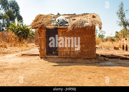 A traditional mud hut with a thatched roof in a rural village near ...