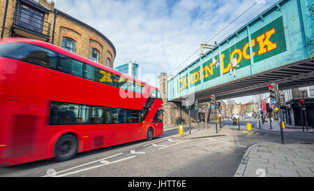 Colorful red double-decker bus moves quickly through motion blur effect ...