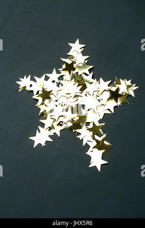 Star of sequins on a black background Stock Photo - Alamy