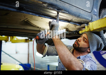 overhaul repair. The young auto mechanic dismantles the opposing engine ...