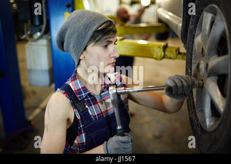 Young woman changing tire of car on roadside Stock Photo - Alamy