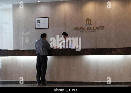 A tourist registers at the reception desk of a hotel in Yangon, Myanmar ...