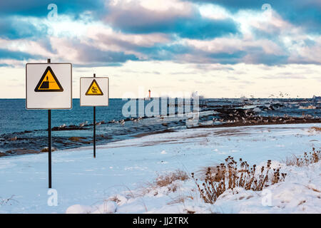 Two yellow warning signs on the winter beach Stock Photo - Alamy