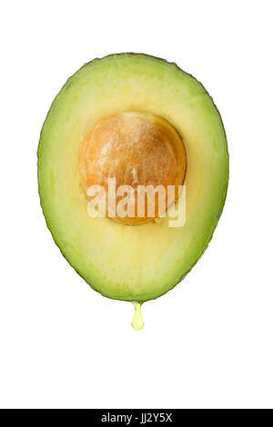 Avocado half on bright yellow background minimal food Stock Photo - Alamy