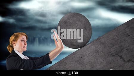 Woman pushing 3D rolling round rock Stock Photo - Alamy