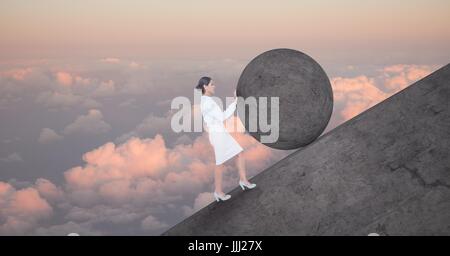 Woman pushing rolling round rock Stock Photo - Alamy
