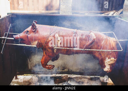 Whole pig roasting at open fire Stock Photo - Alamy