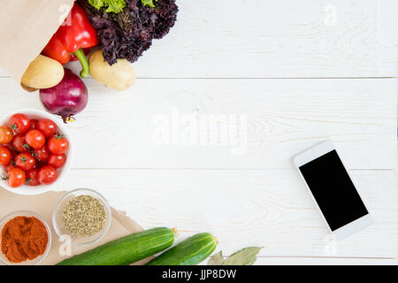 Fresh vegetables, seasonings and smartphone. Fresh ingredients for ...