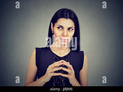 Portrait of sly, scheming woman plotting something isolated on gray ...