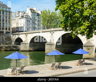 Striped blue beach parasols in the wind, detail Stock Photo - Alamy