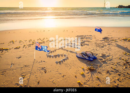 Straya text drawn using shells on sand with flags and thongs. Straya is ...