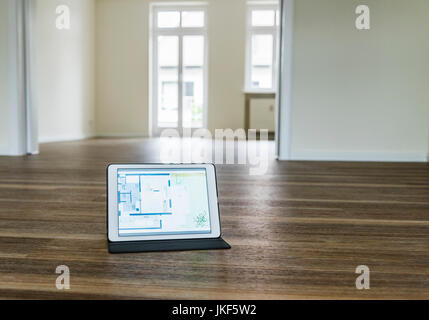 Tablet with floor plan on wooden floor Stock Photo - Alamy
