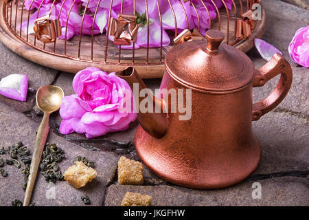 Copper stylish tea pot with tea rose Stock Photo - Alamy