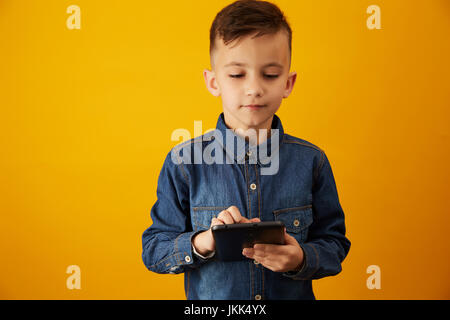 Hands of schoolboy in yellow t-shirt holding climbing carabiner on rope ...